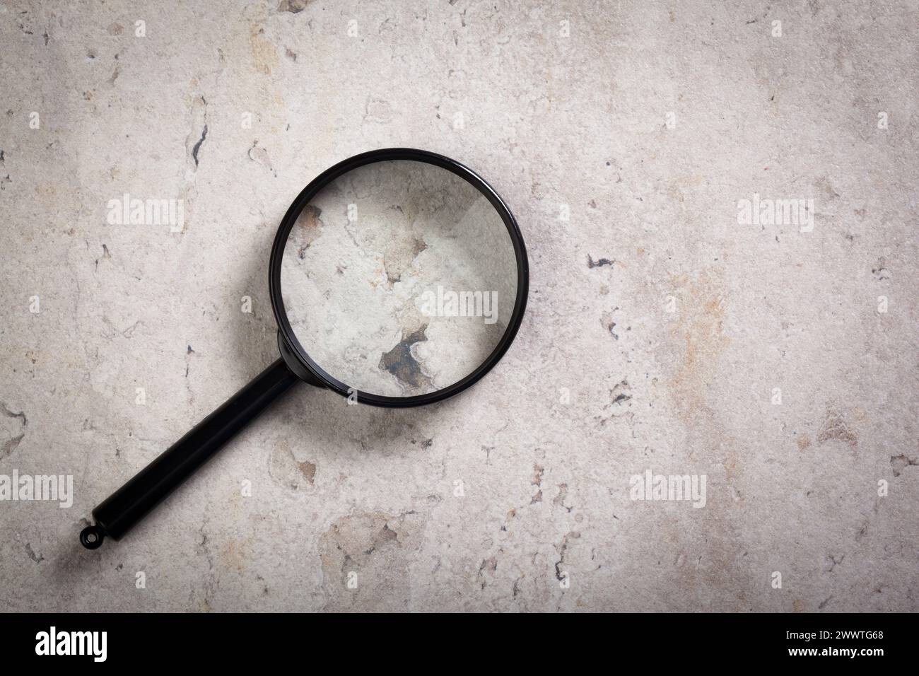 Magnifying glass with empty stone background Stock Photo - Alamy