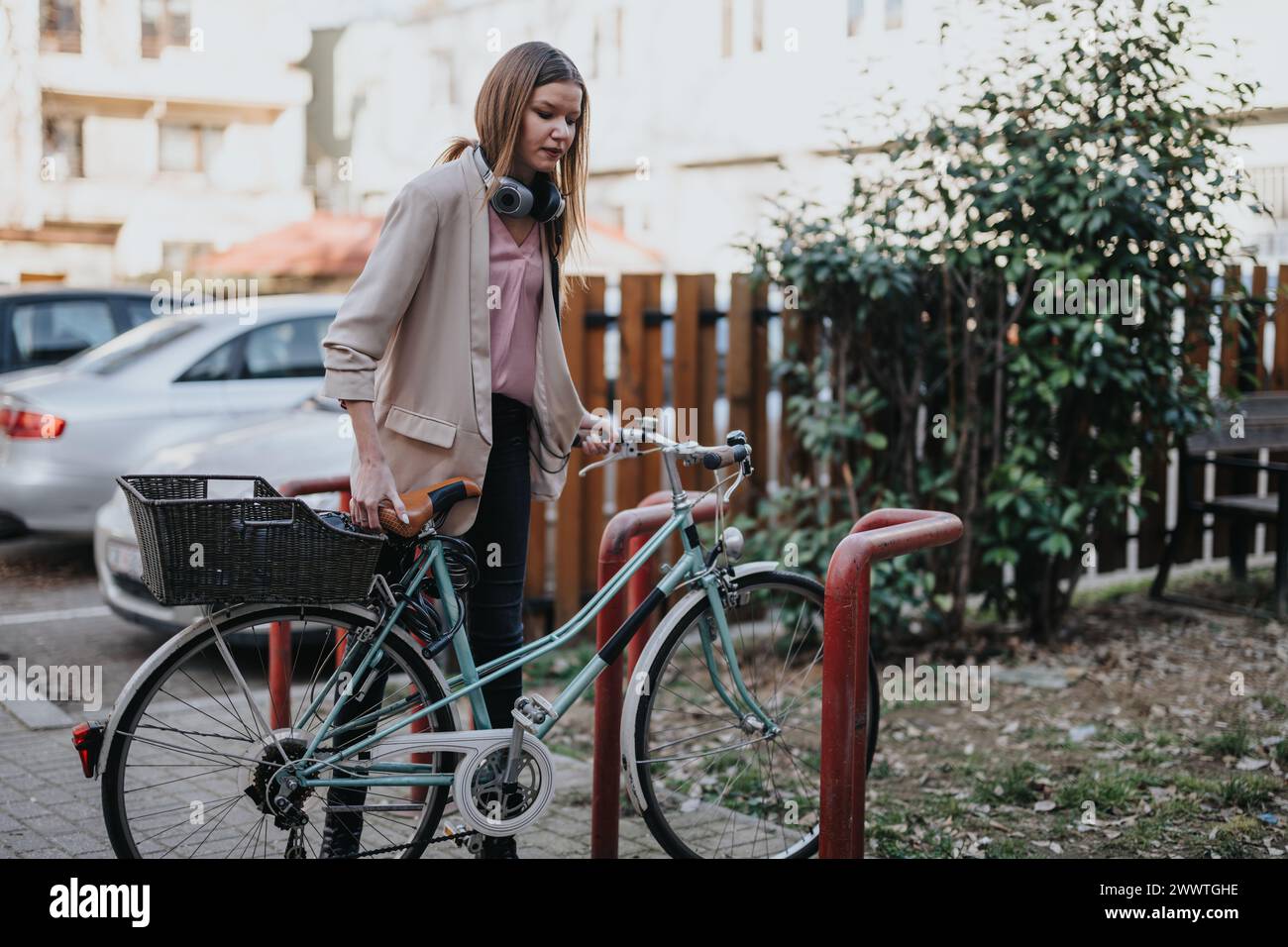 Woman locking her bicycle hi-res stock photography and images - Alamy