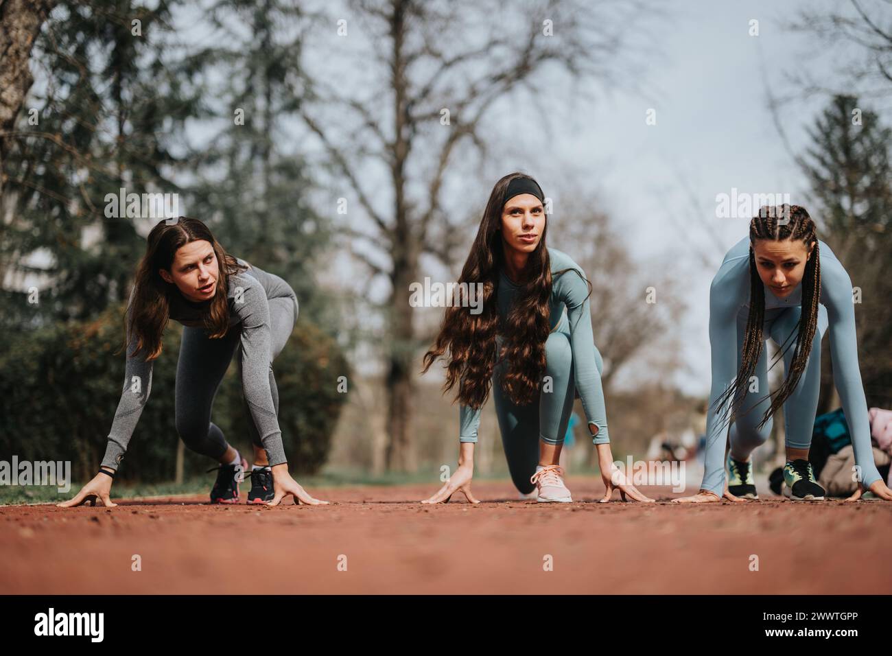 Group of sporty people ready to race at the starting line in a park ...