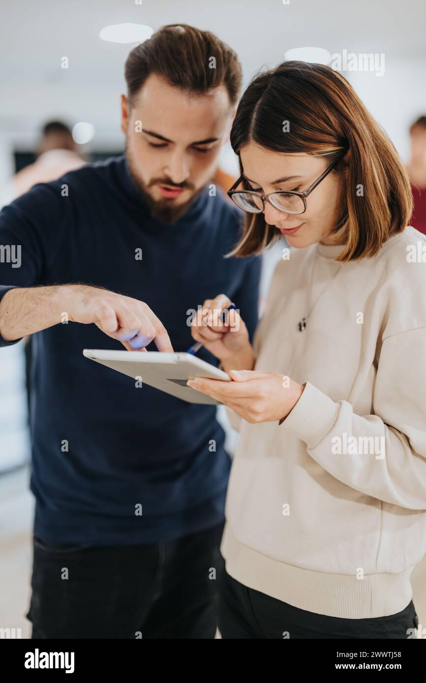 Caucasian colleagues collaborating on a late-night project, driven by ...