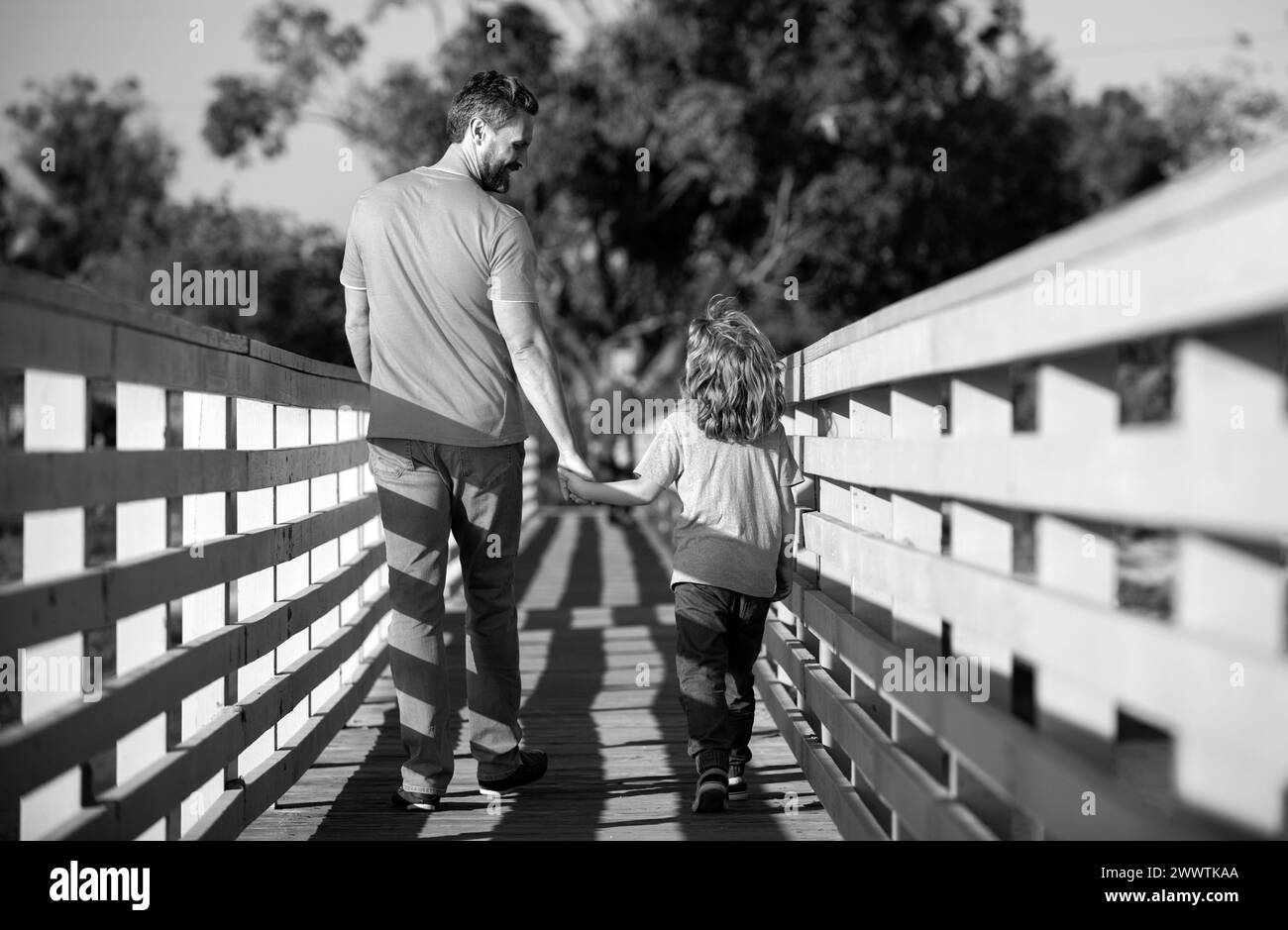 Happy son stretching out hands father. Back view handsome man and cute ...