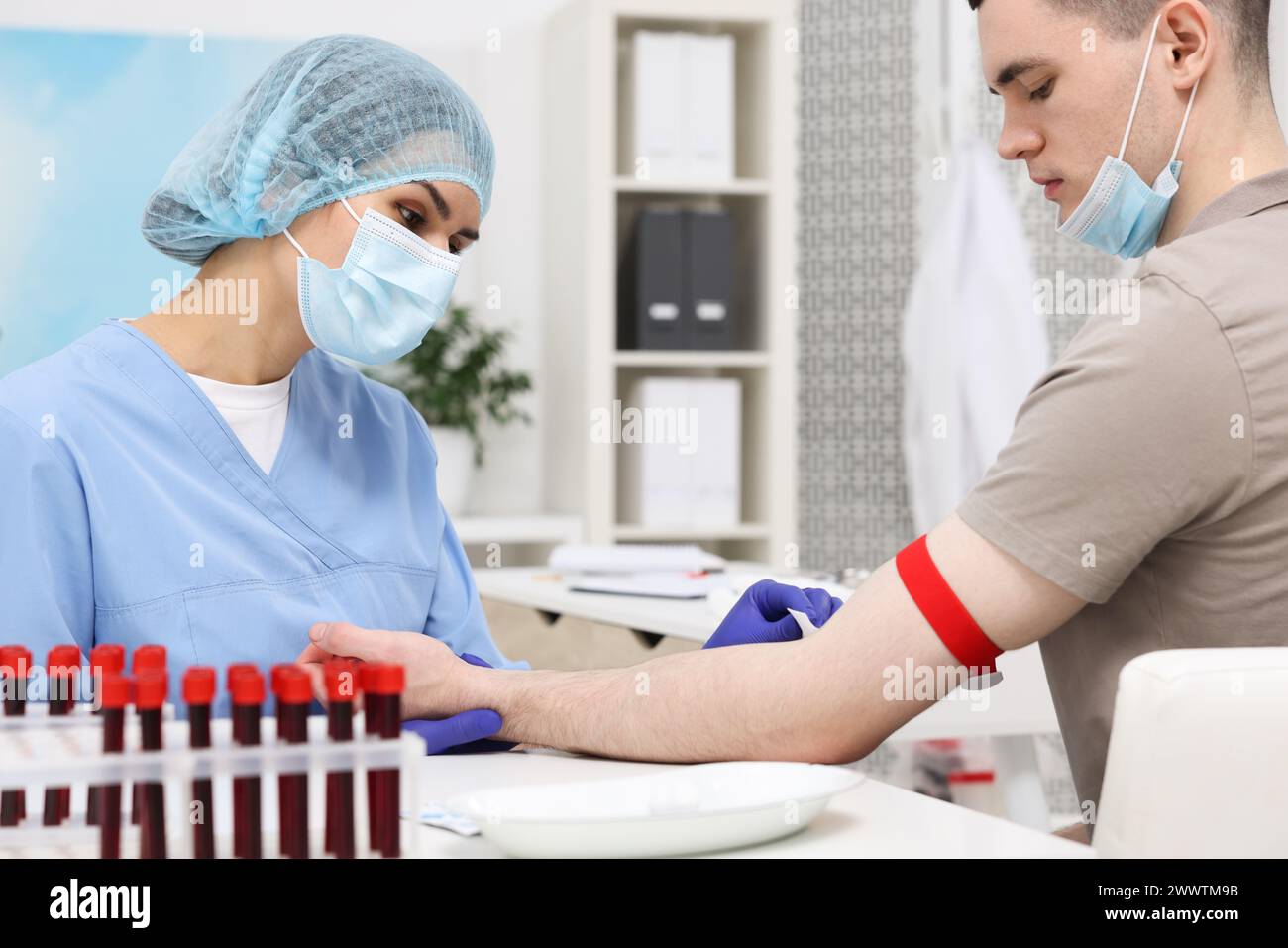 Laboratory testing. Doctor taking blood sample from patient at white ...