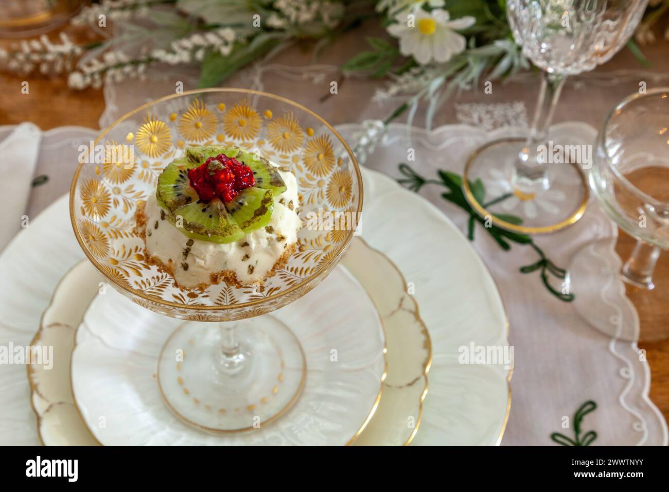 Mini cheesecake with kiwi, raspberry and edible gold garnish on a ...