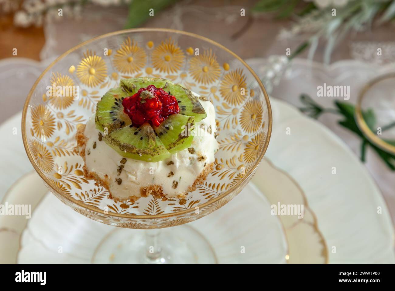 Mini cheesecake with kiwi, raspberry and edible gold garnish on a ...