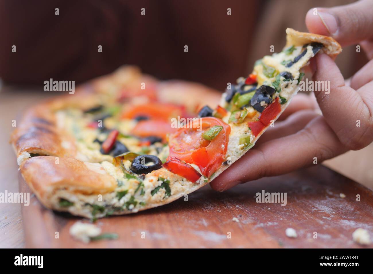 hand picking slice of pizza from a plate Stock Photo - Alamy