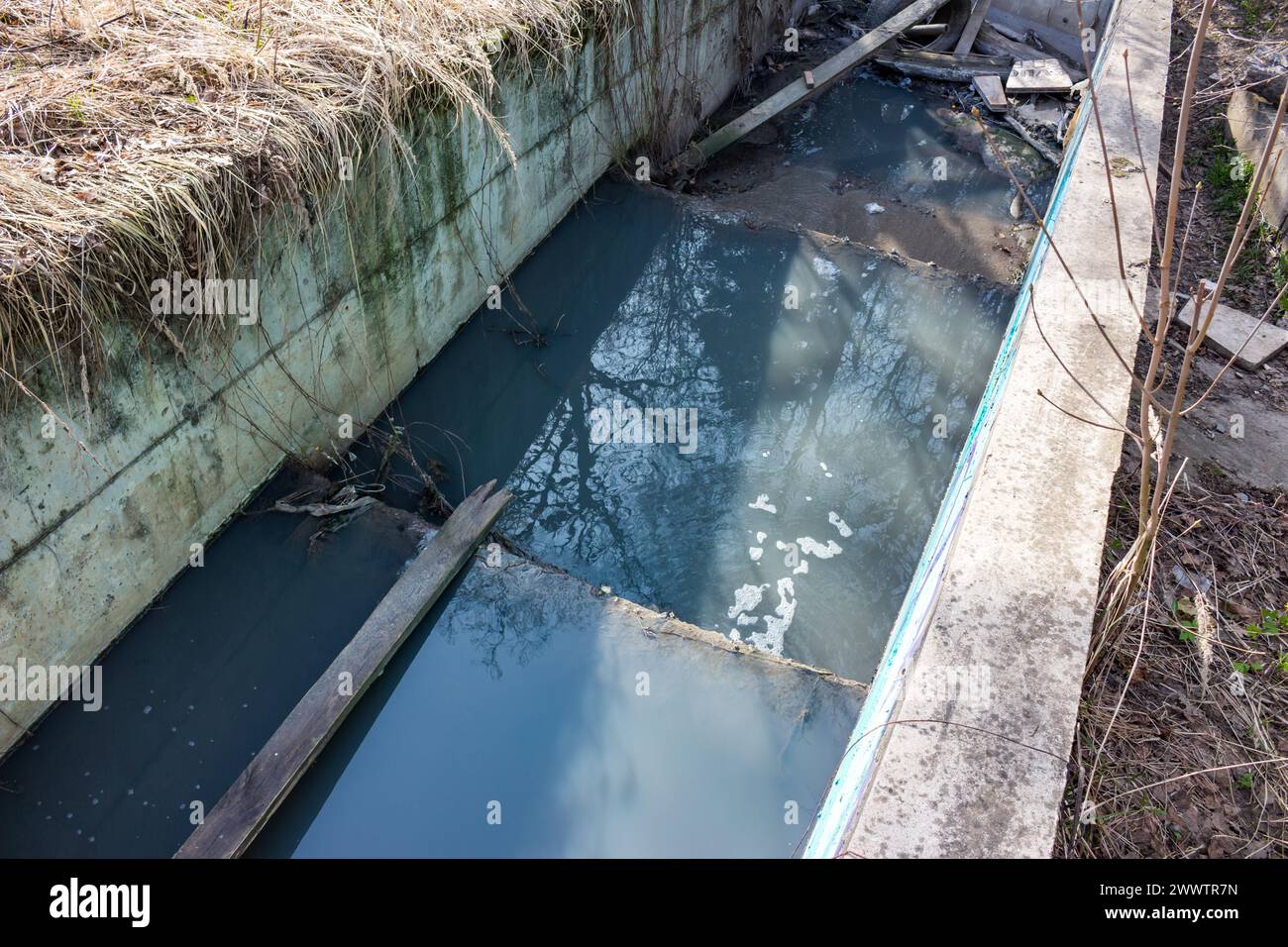 Drainage of stinking bluish liquid being discharged into a storm sewer ...