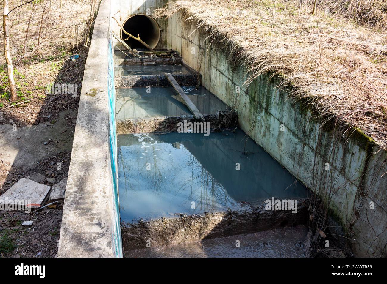 Storm drain coming out with muddy slurry flowing out Stock Photo - Alamy