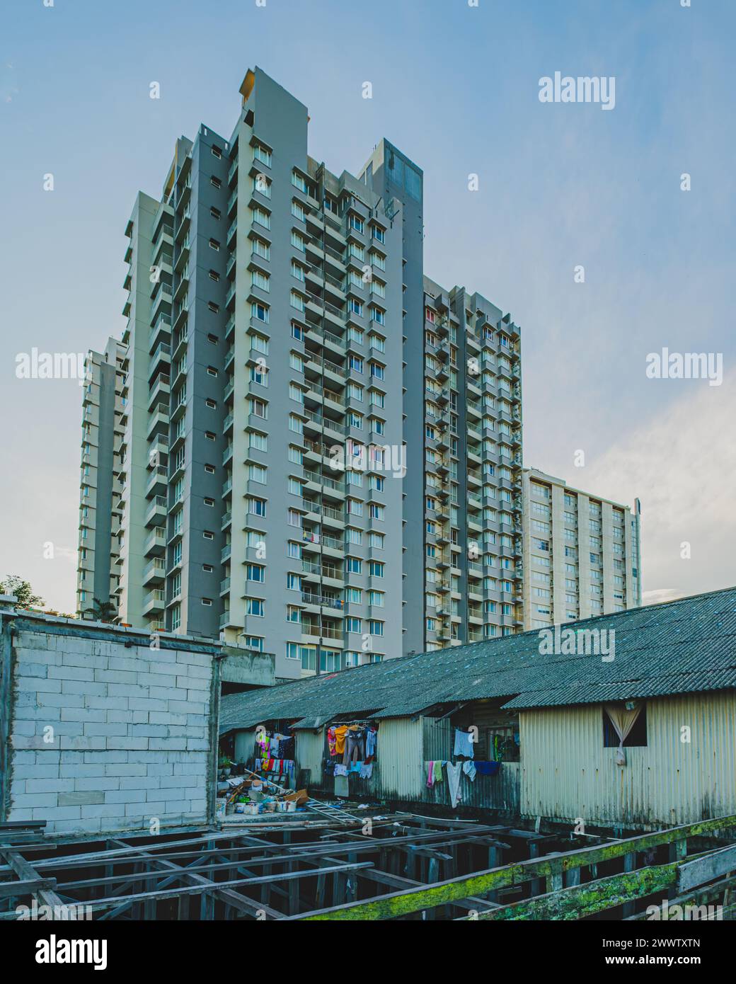 A photo contrasting a modern high rise office building with a small ...