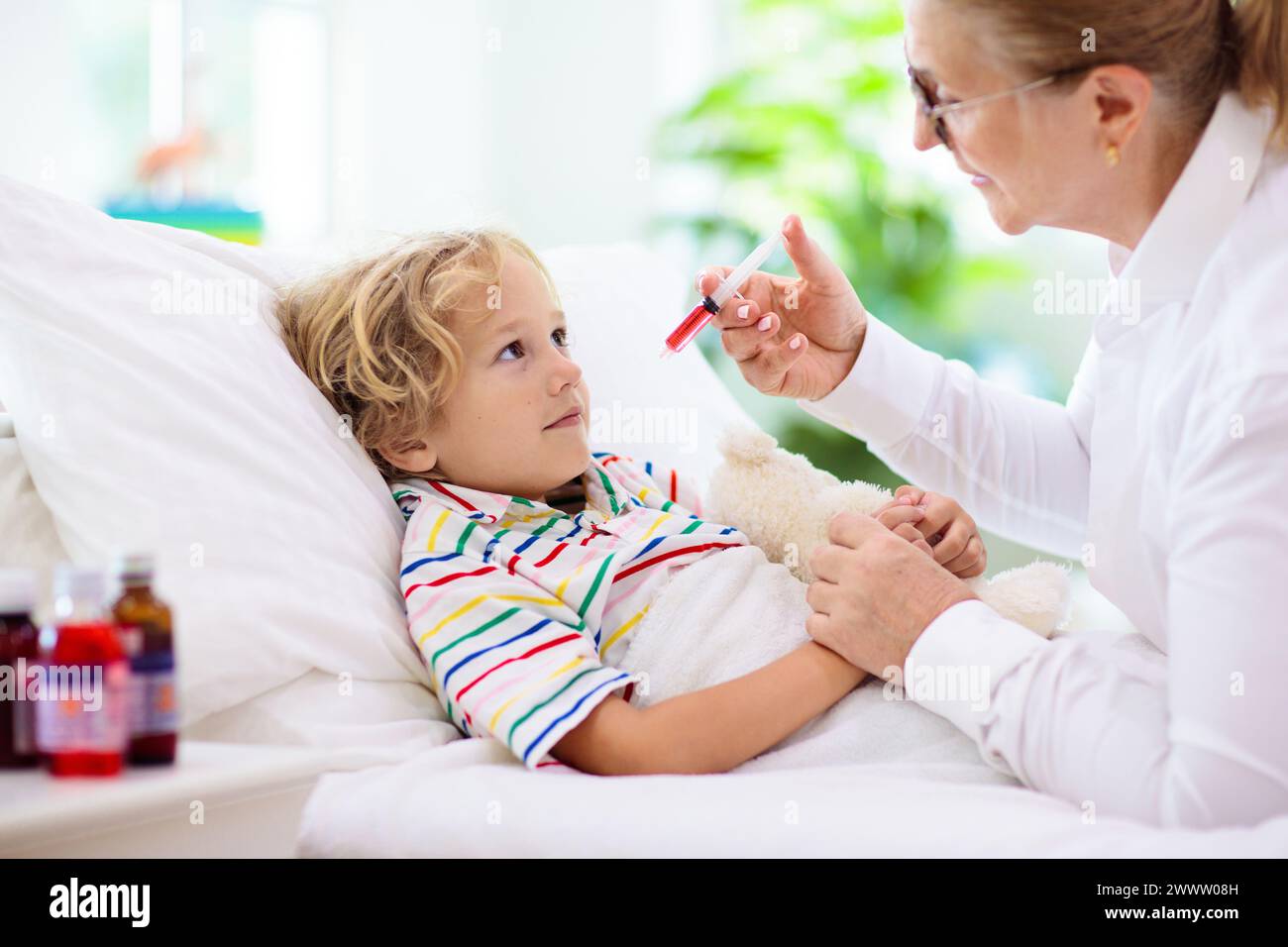 Sick little boy with medicine. Mother checking fever of ill child in ...