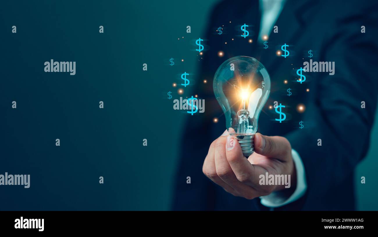 Businessman holding a light bulb with glowing money dollar signs ...
