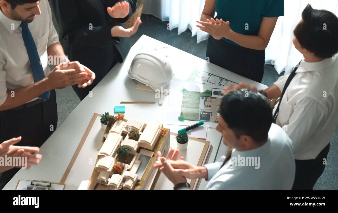 Top view of team clapping hands to celebrate project at meeting table ...