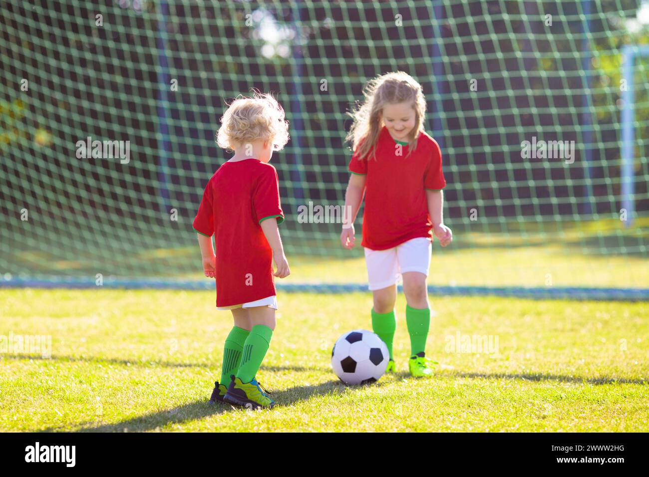 Kids play football on outdoor field. Portugal team fans. Children score ...