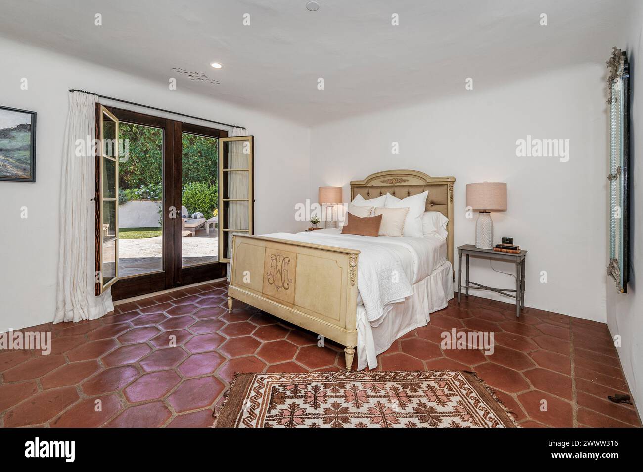 A wooden bed beside a sliding glass door in a bedroom Stock Photo - Alamy