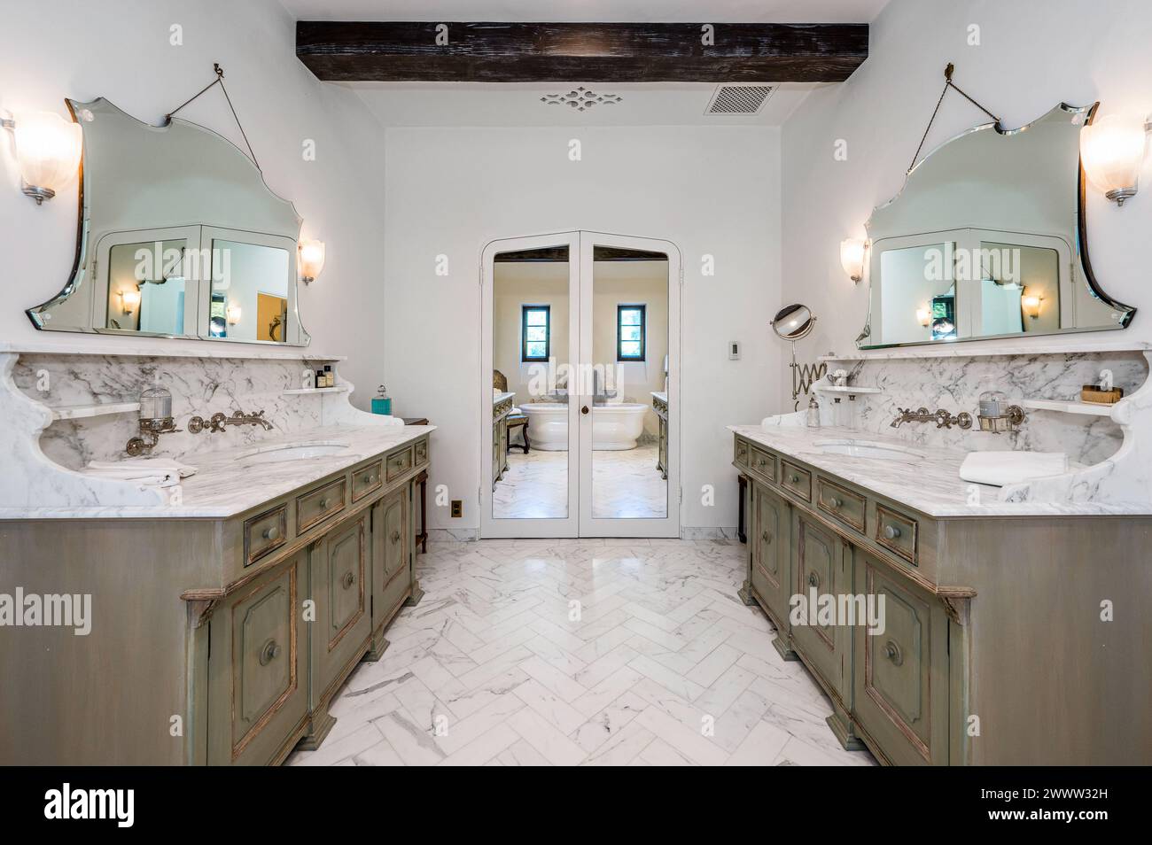 Bathroom with double sinks, lit mirrors above Stock Photo - Alamy