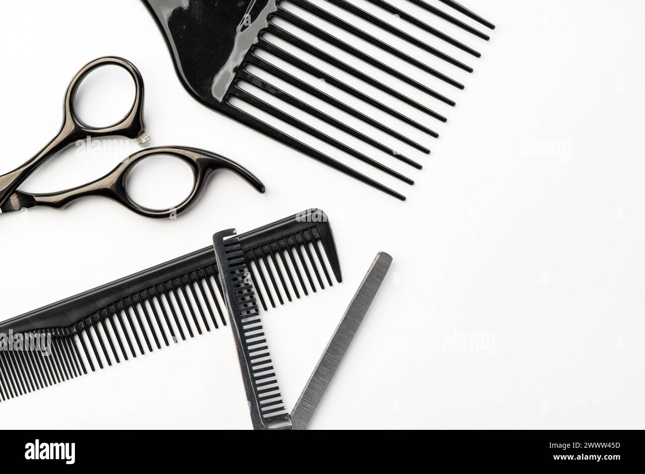 Black hairdressing tools and various hairbrushes on white background ...