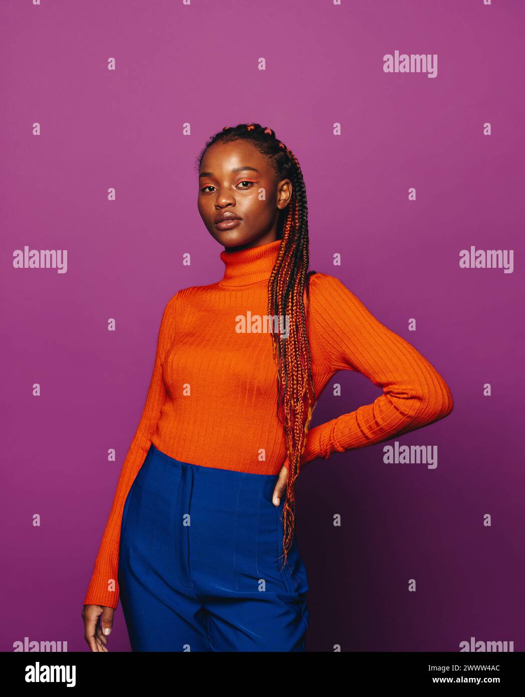 Confident girl with two-tone braids and trendy makeup stands in a ...
