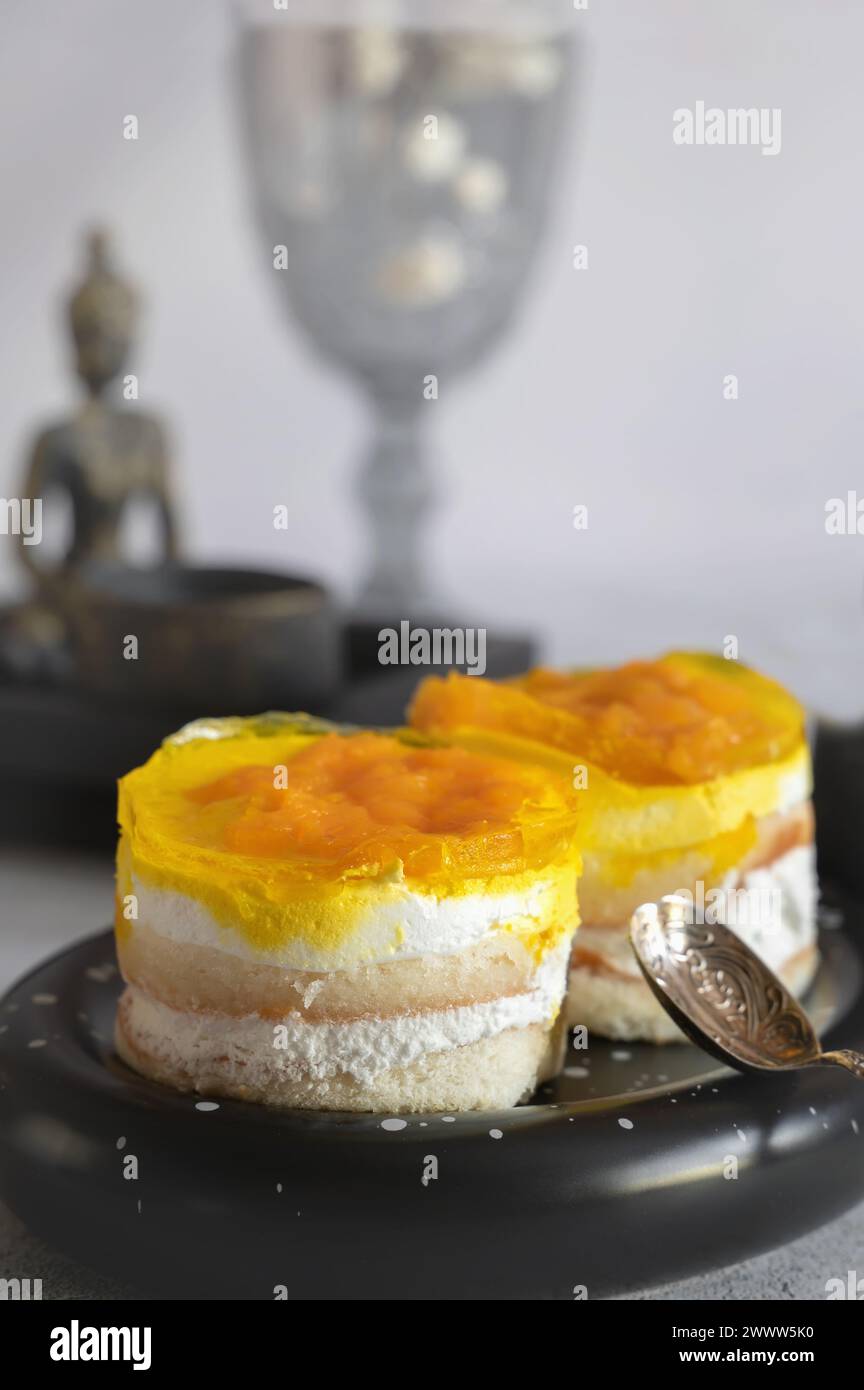 yoghurt dessert with sponge cake, orange and peach. The surface of the ...