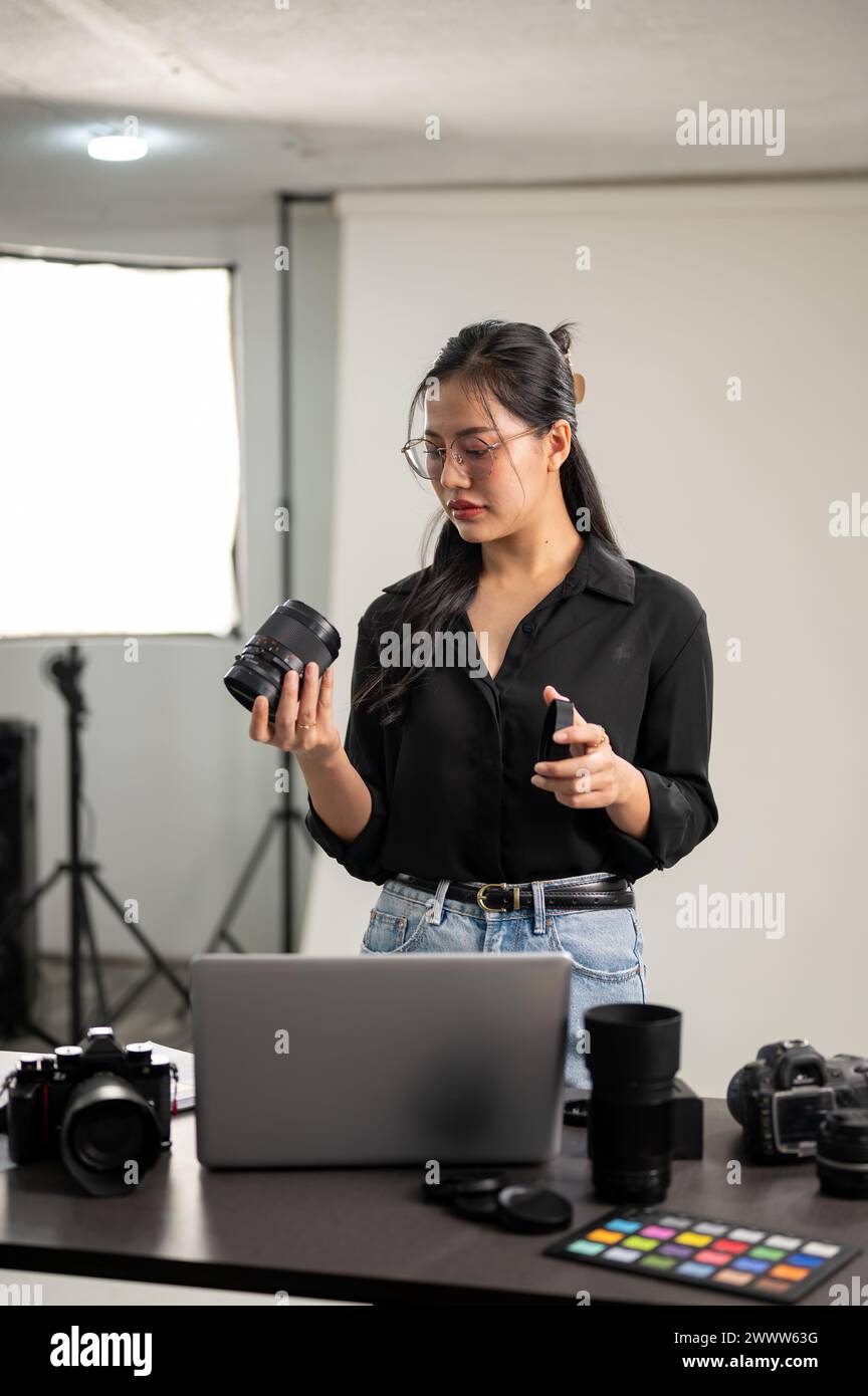 A professional, attractive Asian female photographer is preparing her ...