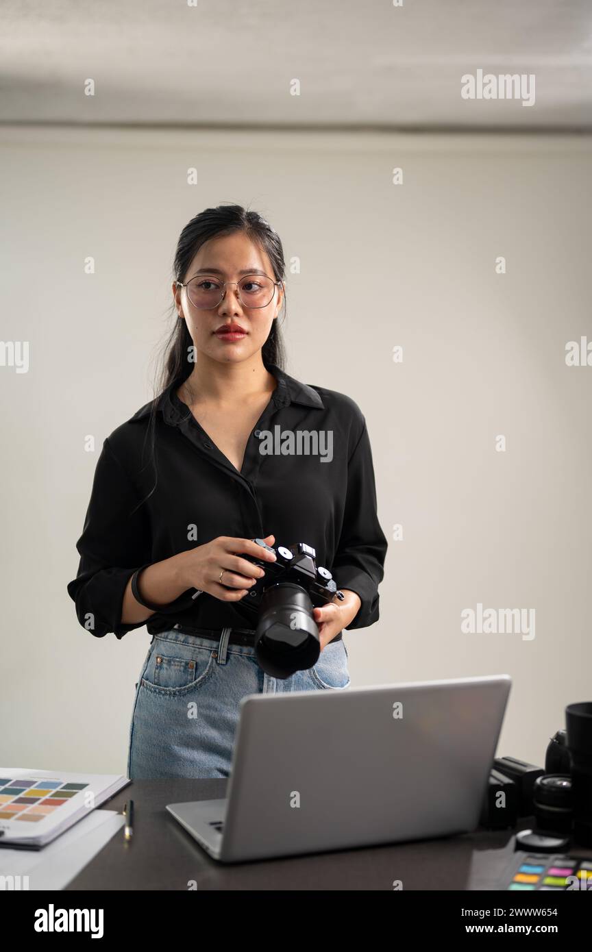 An elegant, professional Asian female photographer in a black shirt ...
