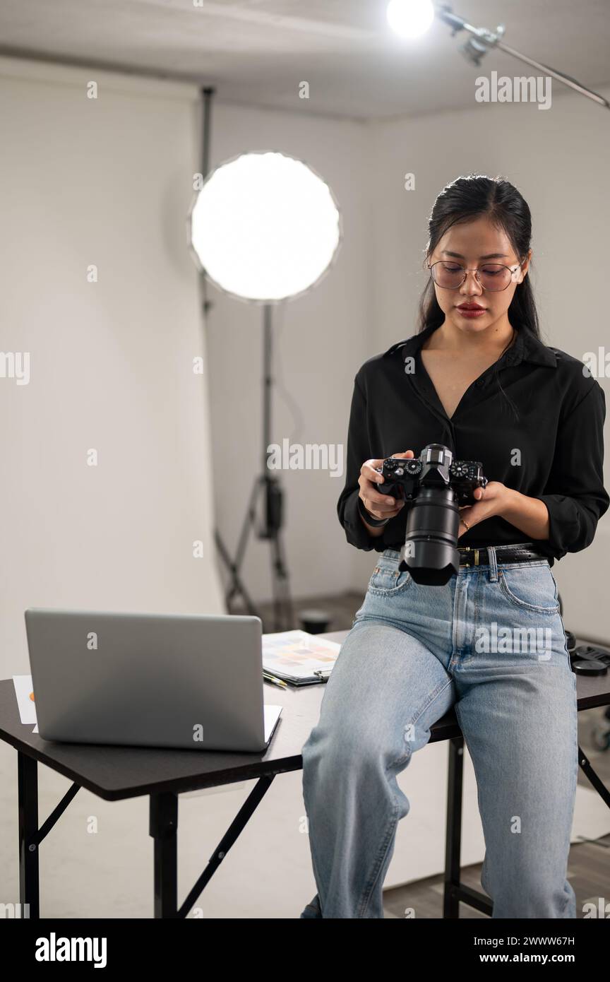 A professional Asian female photographer is focusing on adjusting her ...