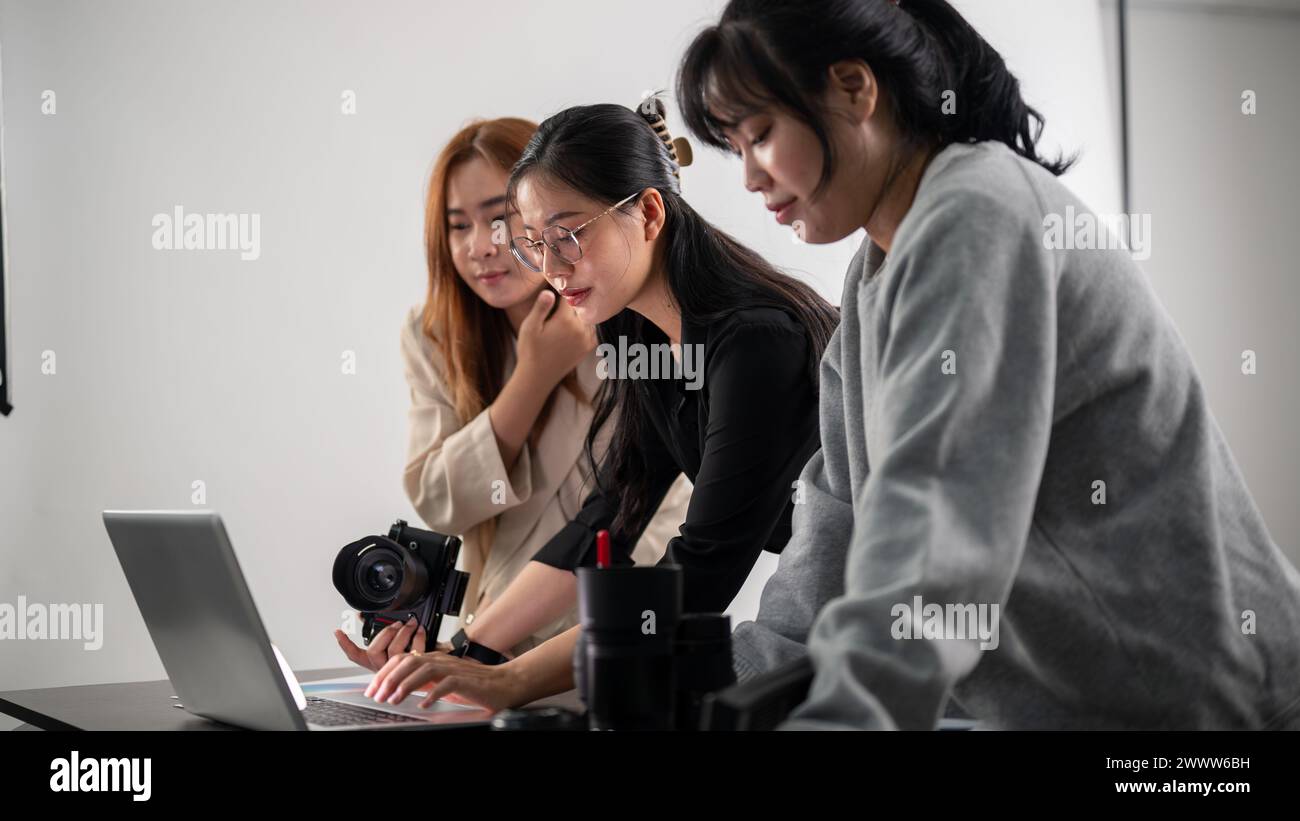 A professional Asian female photographer is working with her assistants ...