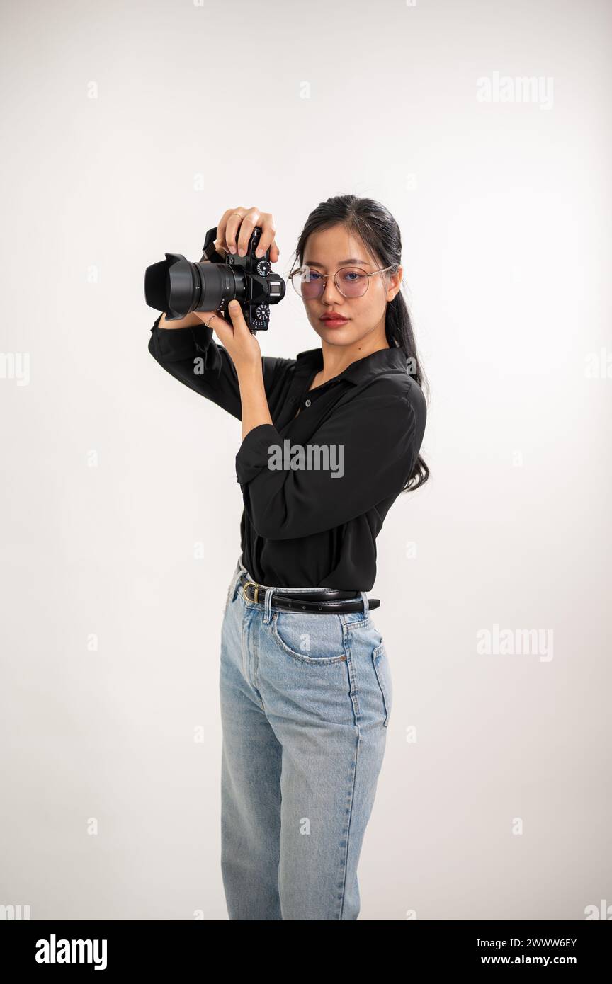A professional, confident Asian female photographer in a black shirt is ...