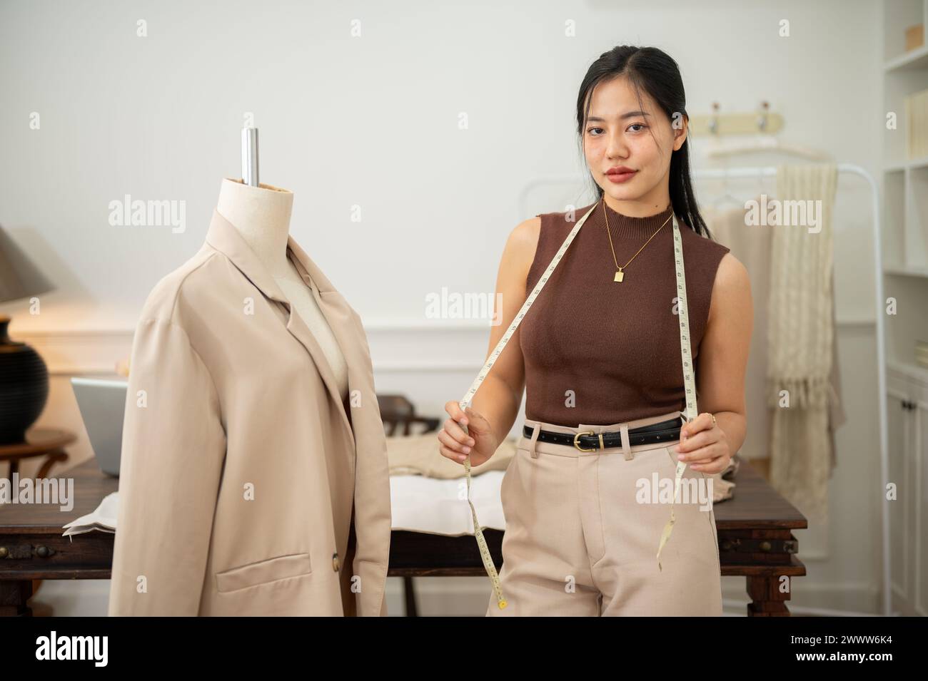 An attractive and confident Asian female tailor or fashion designer is ...