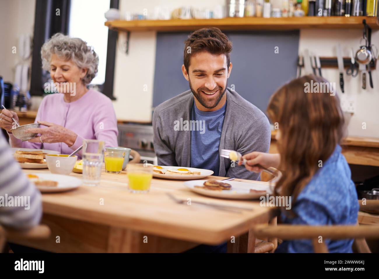 Love, breakfast and family in a kitchen with pancakes, eating or ...
