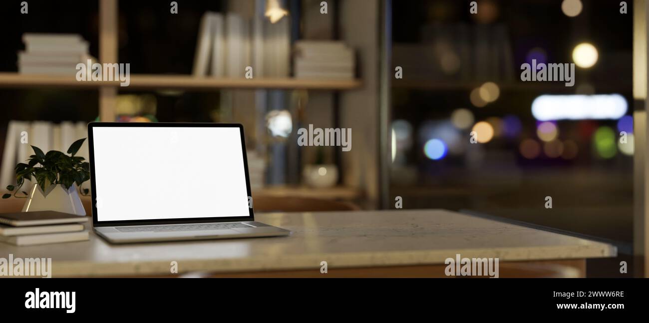 A white-screen laptop computer mockup on a desk in a modern home office ...