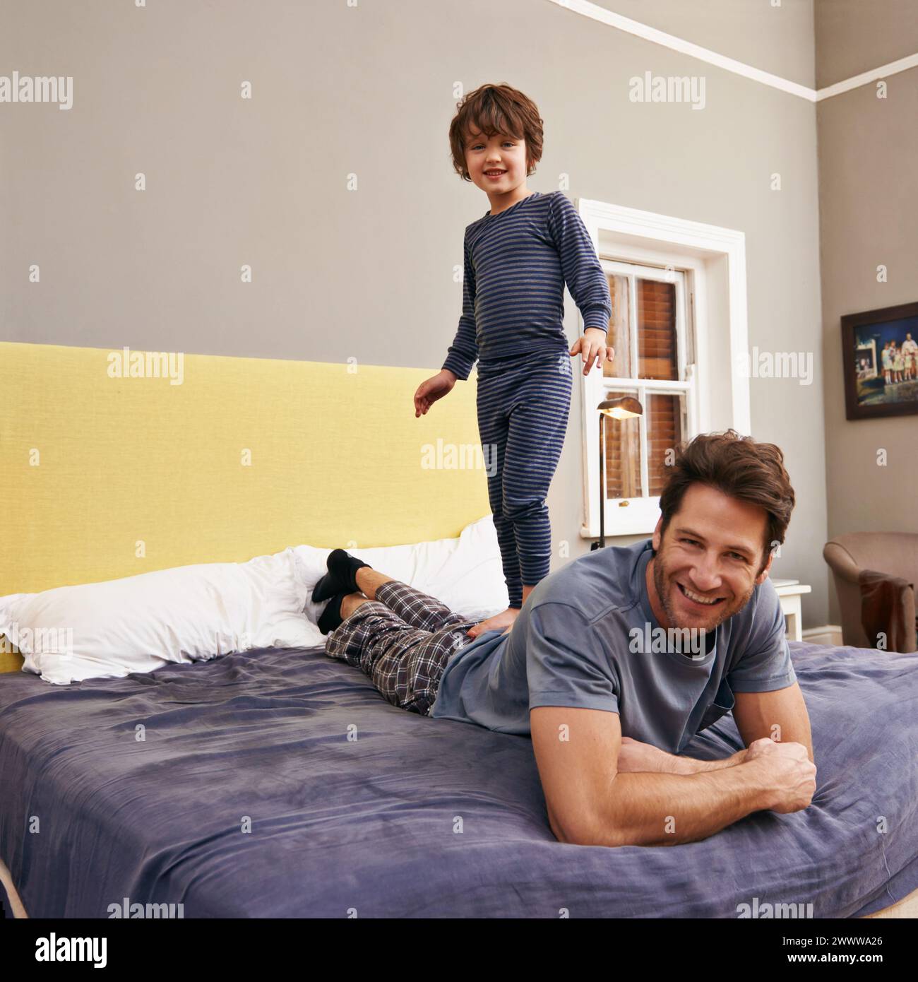 Happy, jumping and father with kid on bed bonding, playing and having ...