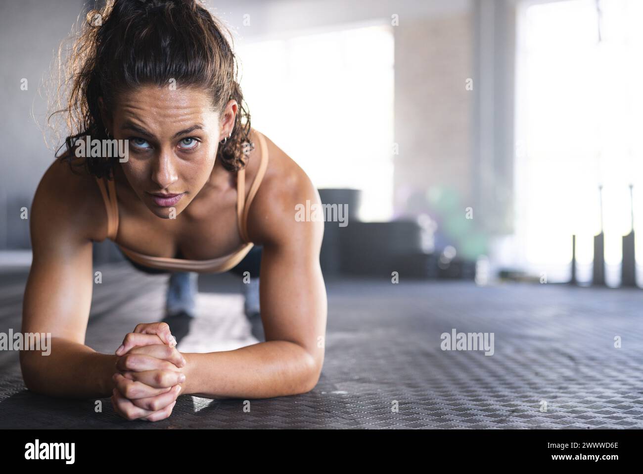 A fit Caucasian woman is holding a plank position in the gym with copy ...