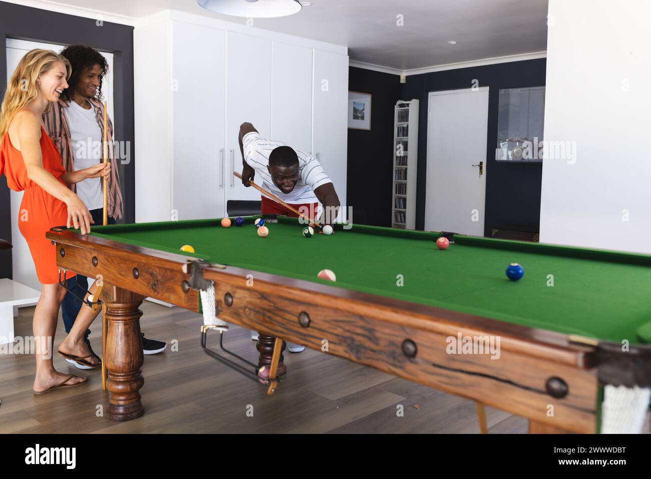 A diverse group of friends enjoys a game of pool with copy space Stock ...