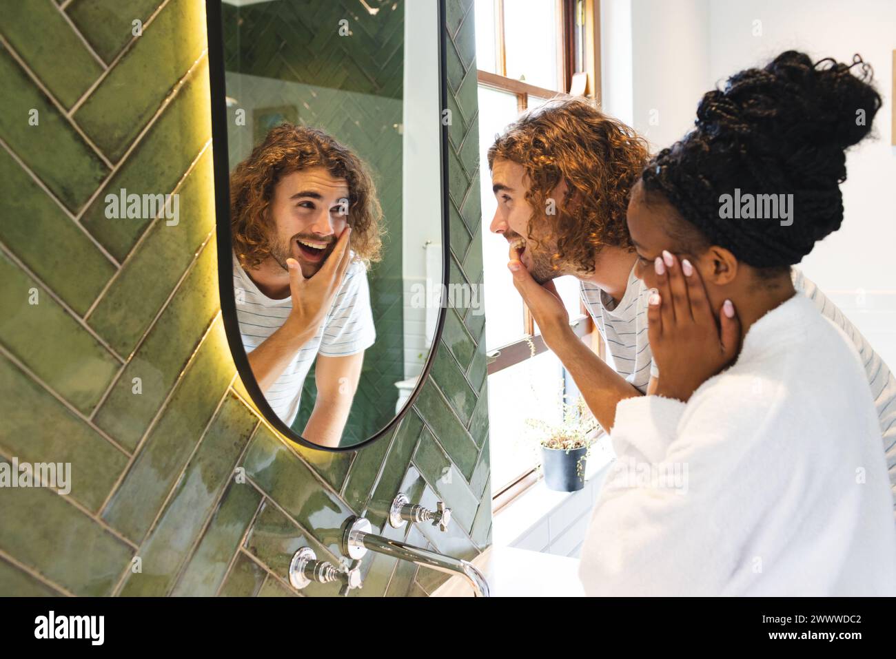 A diverse couple is engaging in their morning skincare routine at home ...