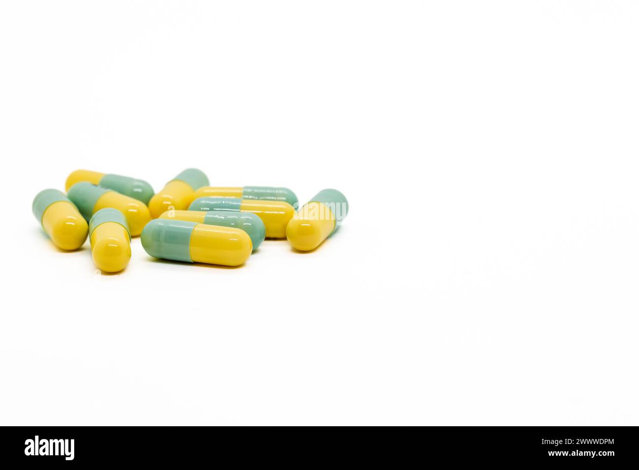 Green and yellow generic pills on a white background with free space ...