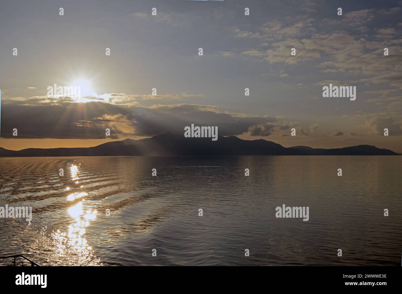 SUN RAYS PEERING THROUGH THE CLOUDS ABOVE THE ISLE OF ARRAN ONTO THE ...