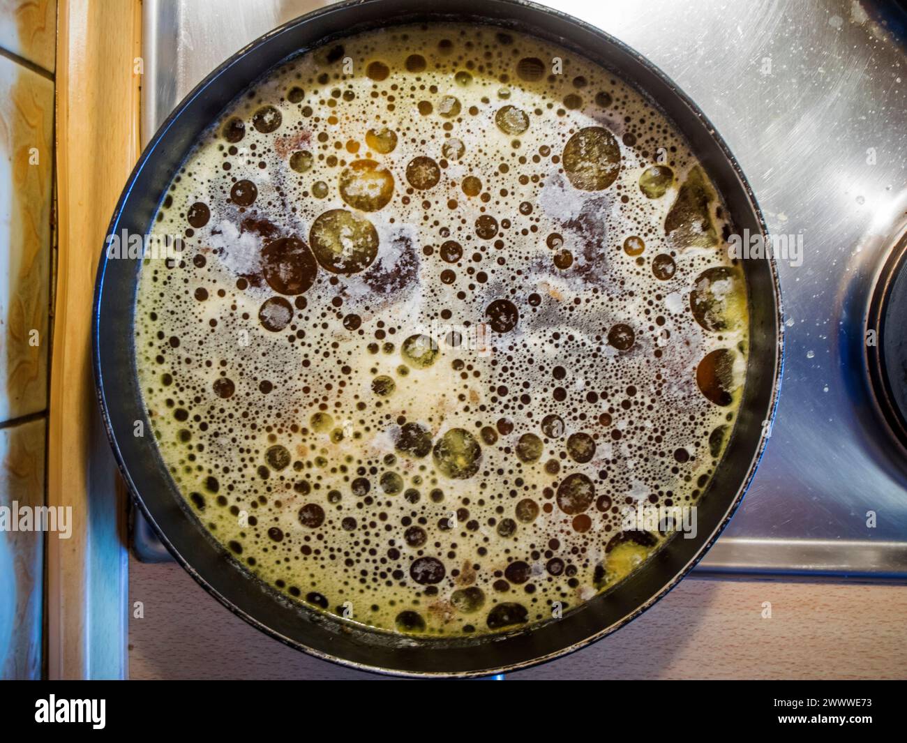 Top view of a round frying pan with grease eyes on an electric stove ...