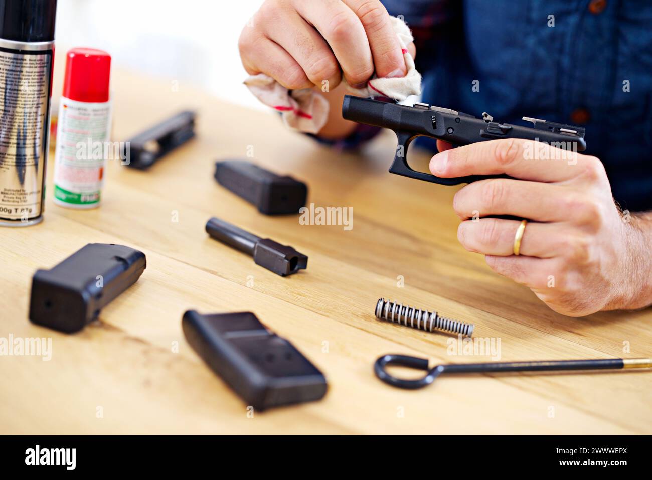 Hands, man with gun cleaning process at table for safety, self defense ...