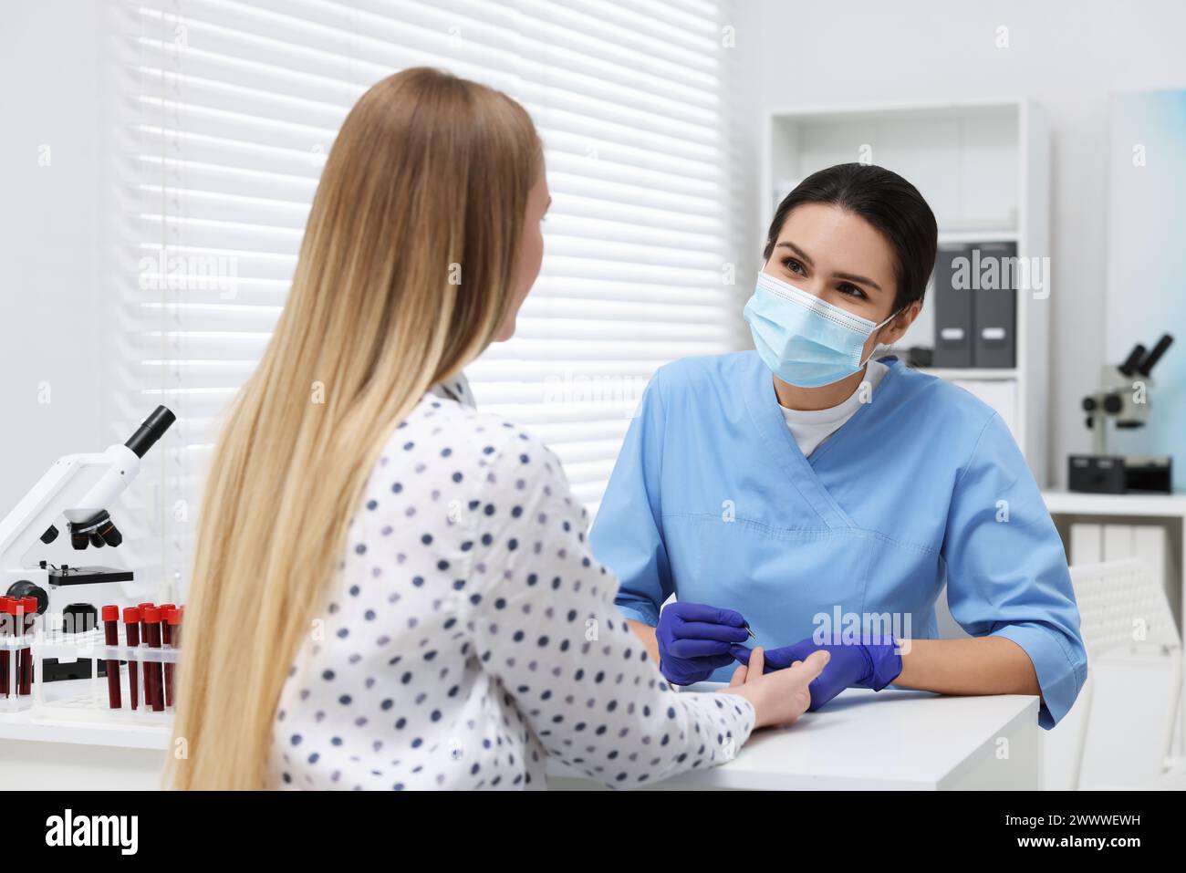 Laboratory testing. Doctor taking blood sample from patient at white ...