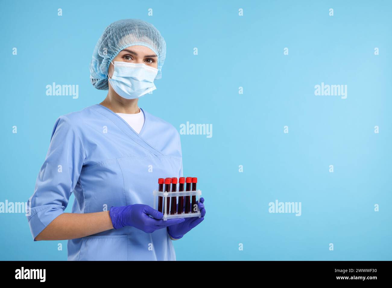 Laboratory testing. Doctor with blood samples in tubes on light blue ...