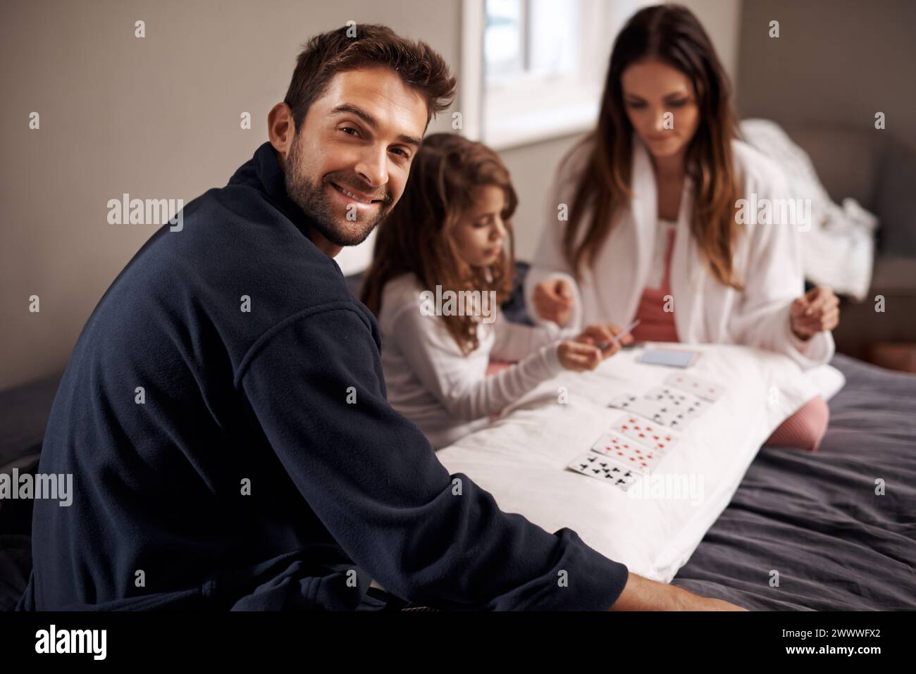 Parents, girl and playing cards for portrait in home with bonding ...