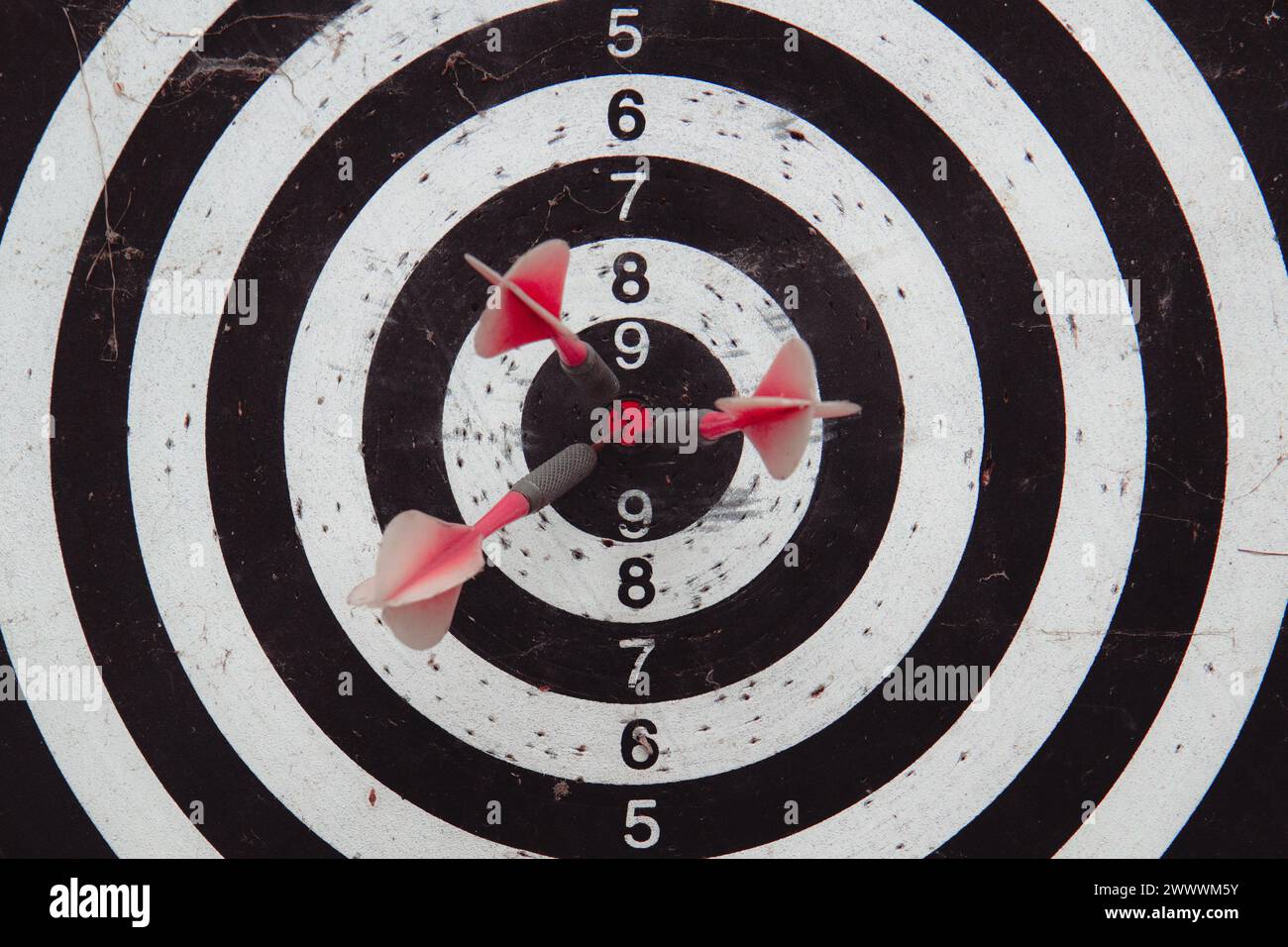 Close up shot red darts arrows in the target center on dark blue sky ...