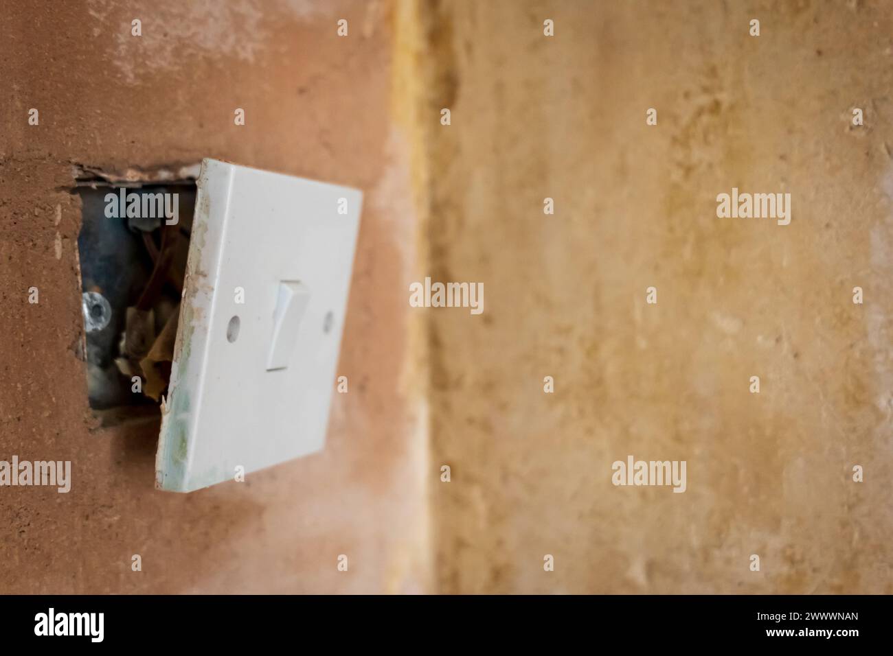 light switch out of rough plastered wall texture closeup during home ...
