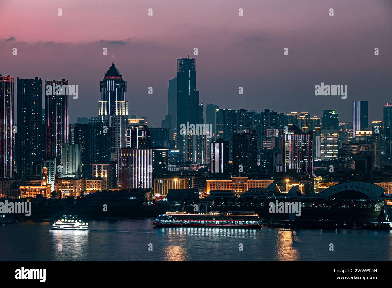 At night, by the Yangtze River, under the sunset, skyscrapers in Wuhan ...
