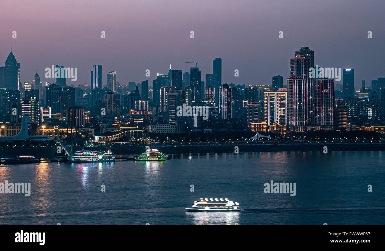 At night, by the Yangtze River, under the sunset, skyscrapers in Wuhan ...