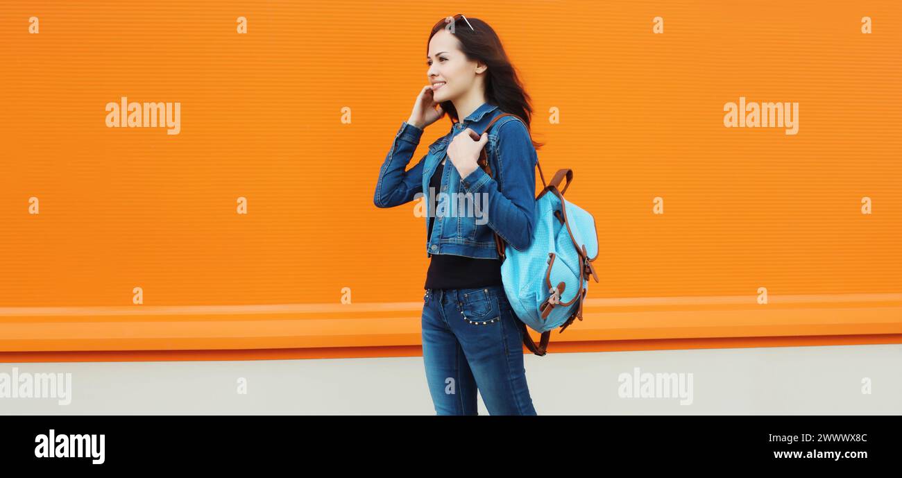 Modern happy young woman calling on mobile phone in denim jacket with ...