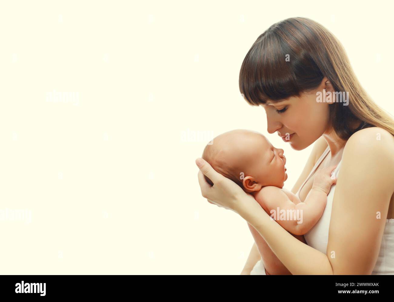 Happy young mother holding cute infant, baby sleeping in arms on white studio background Stock ...
