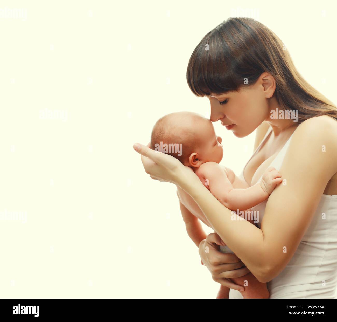 Happy young mother holding cute infant, baby sleeping in arms on white studio background Stock ...