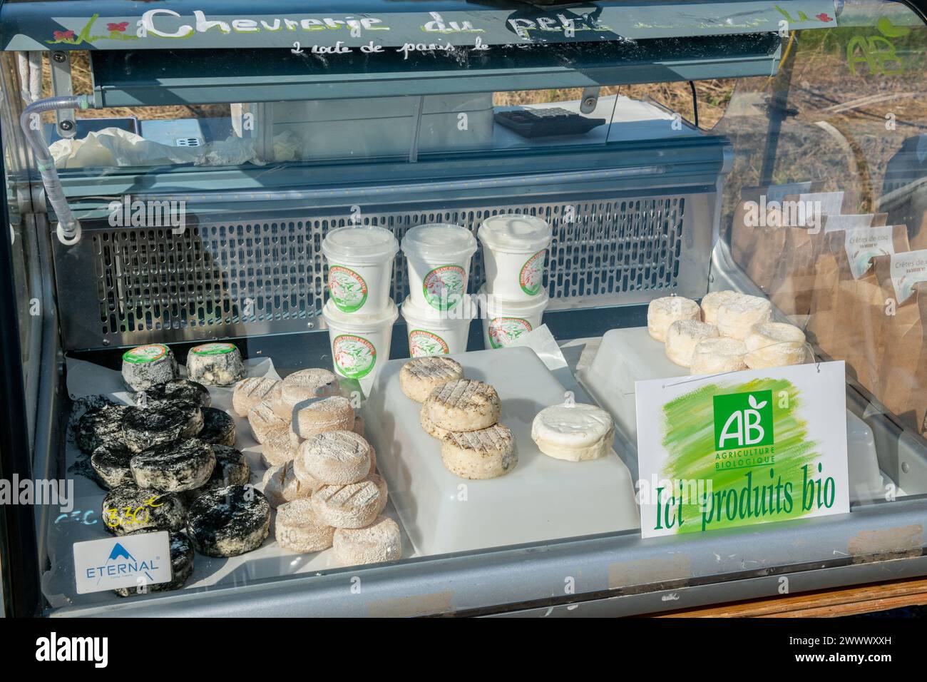 Direct sale at a farm market: organic goat’s cheese in a refrigerated ...