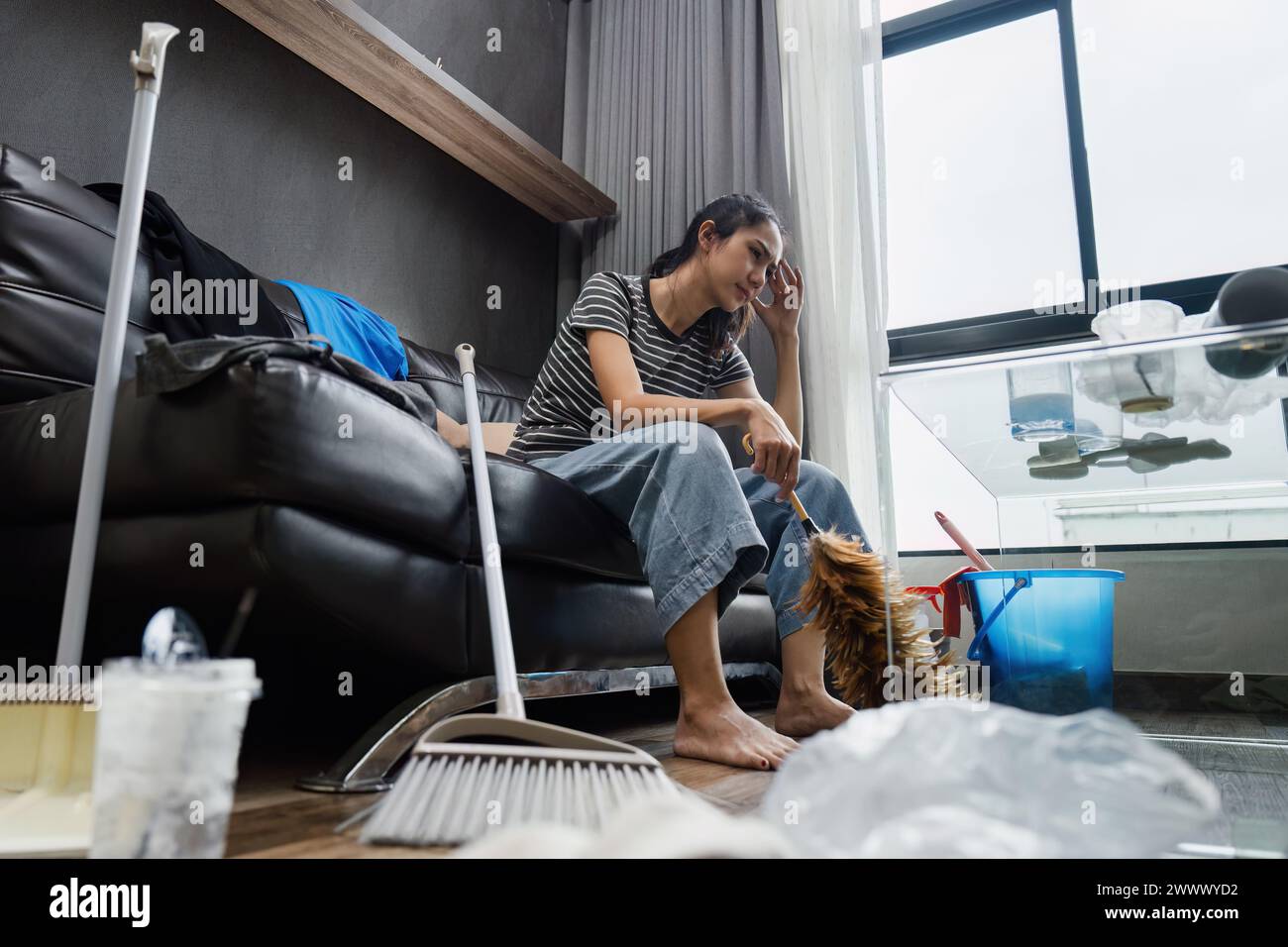 Shocked woman with messing home while cleaning house. Young girl ...