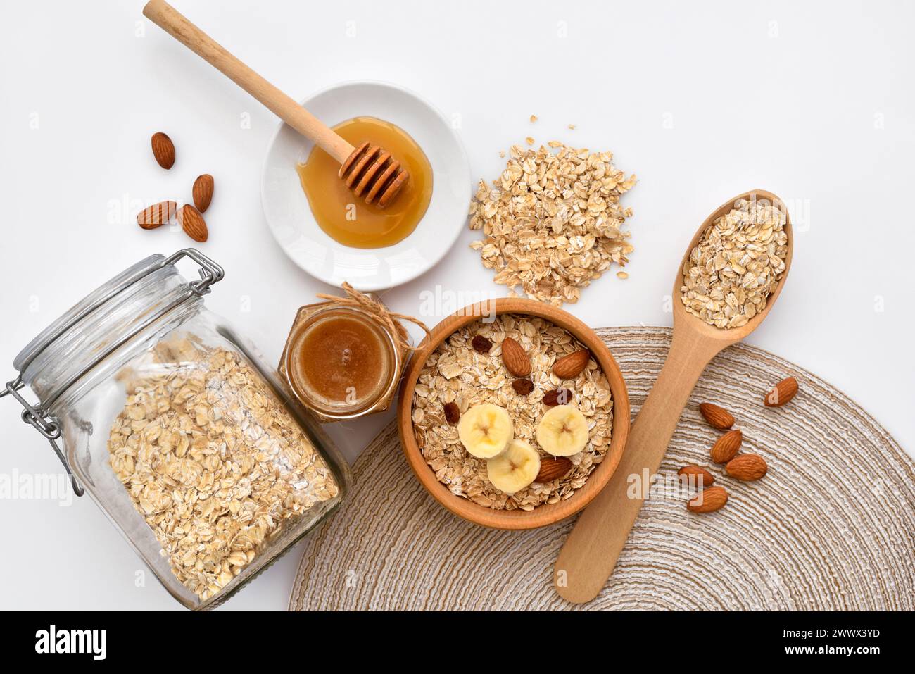 Oatmeal in a wooden bowl with almonds and pieces of banana ready to ...